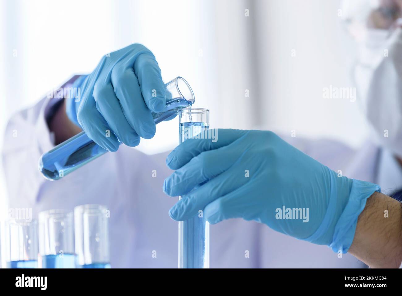 Scientist pouring liquid flask hi-res stock photography and images - Alamy