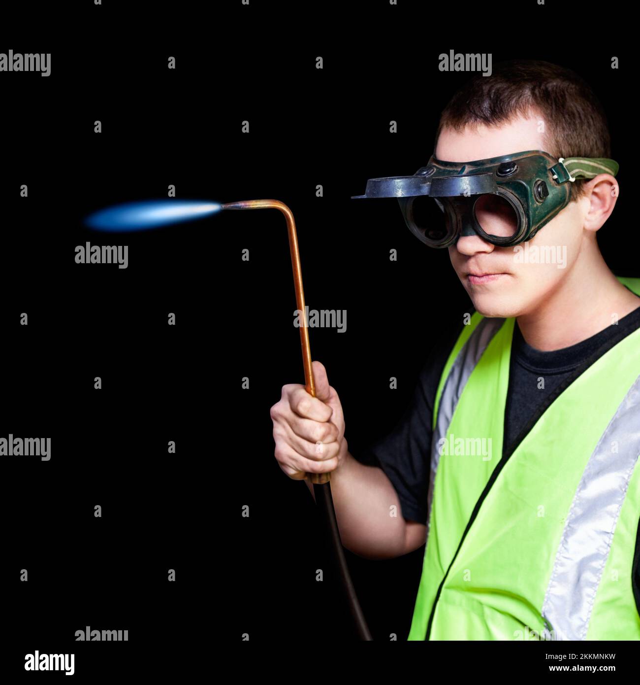 Panelbeater in safety goggles holding the nozzle of an oxyacetylene ...