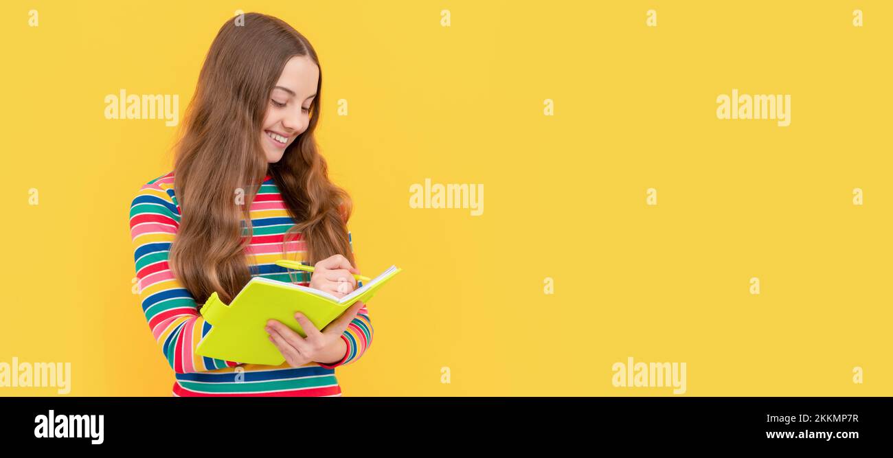 Happy girl child write down in copybook yellow background, literacy ...