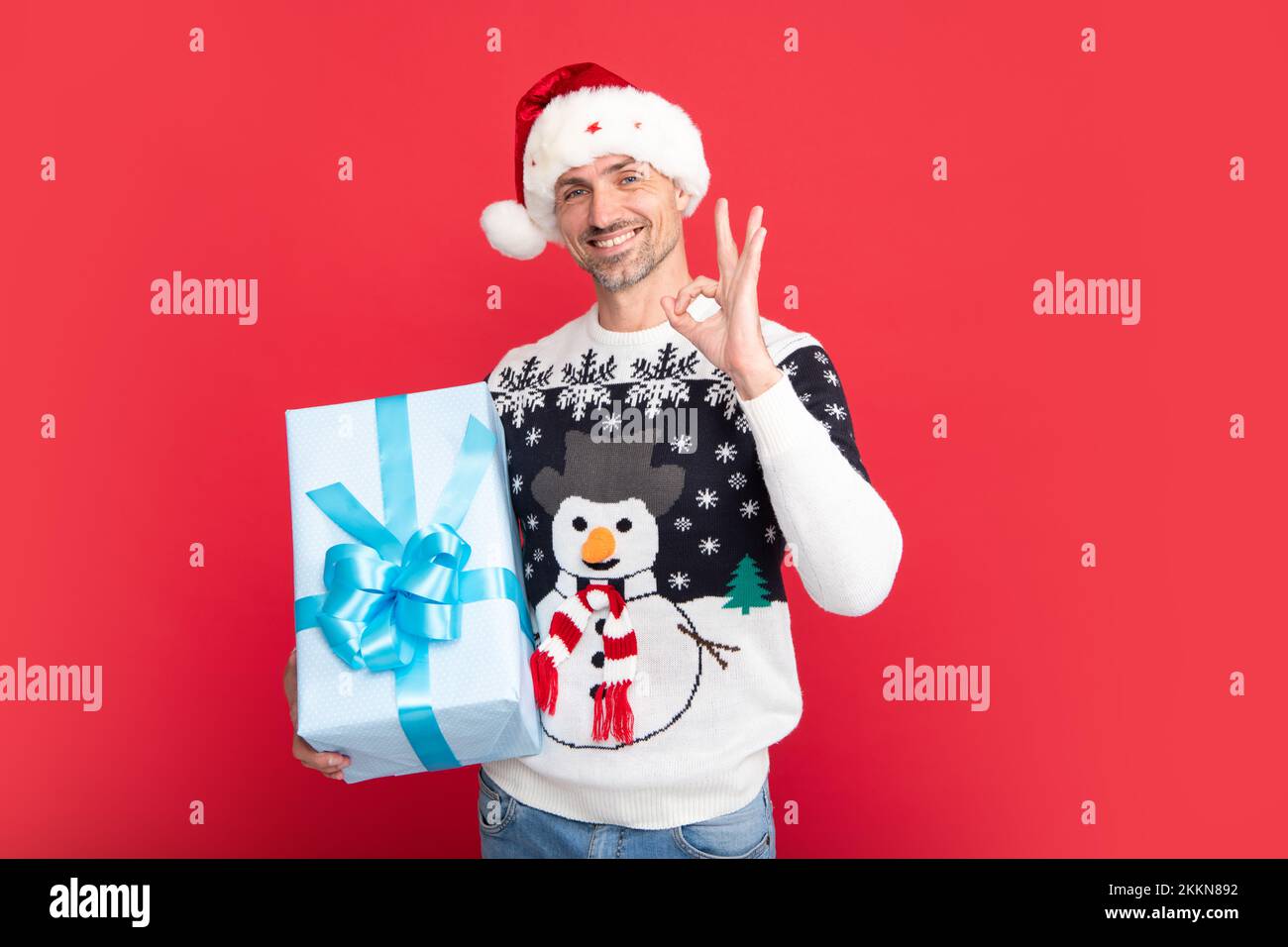 Man in Christmas sweater and hat on color background. Santa with ...