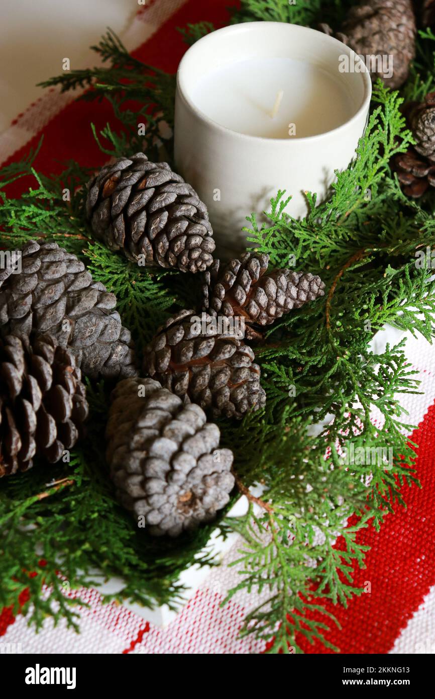 christmas composition with a candle, pine cones and green needles with ...