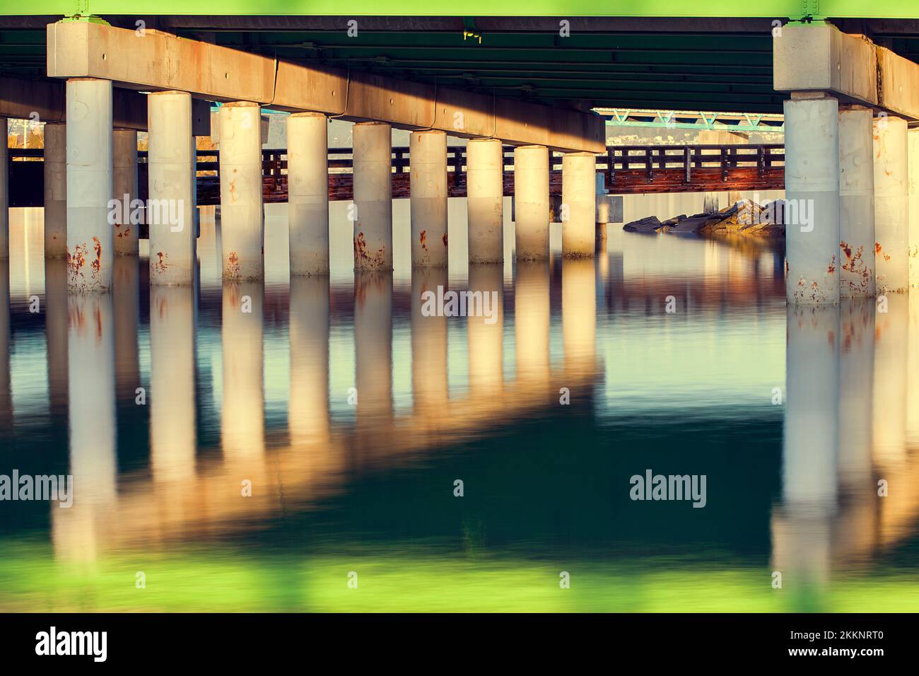 Close-up bridge pillars and reflections, lit by late sunlight Stock ...