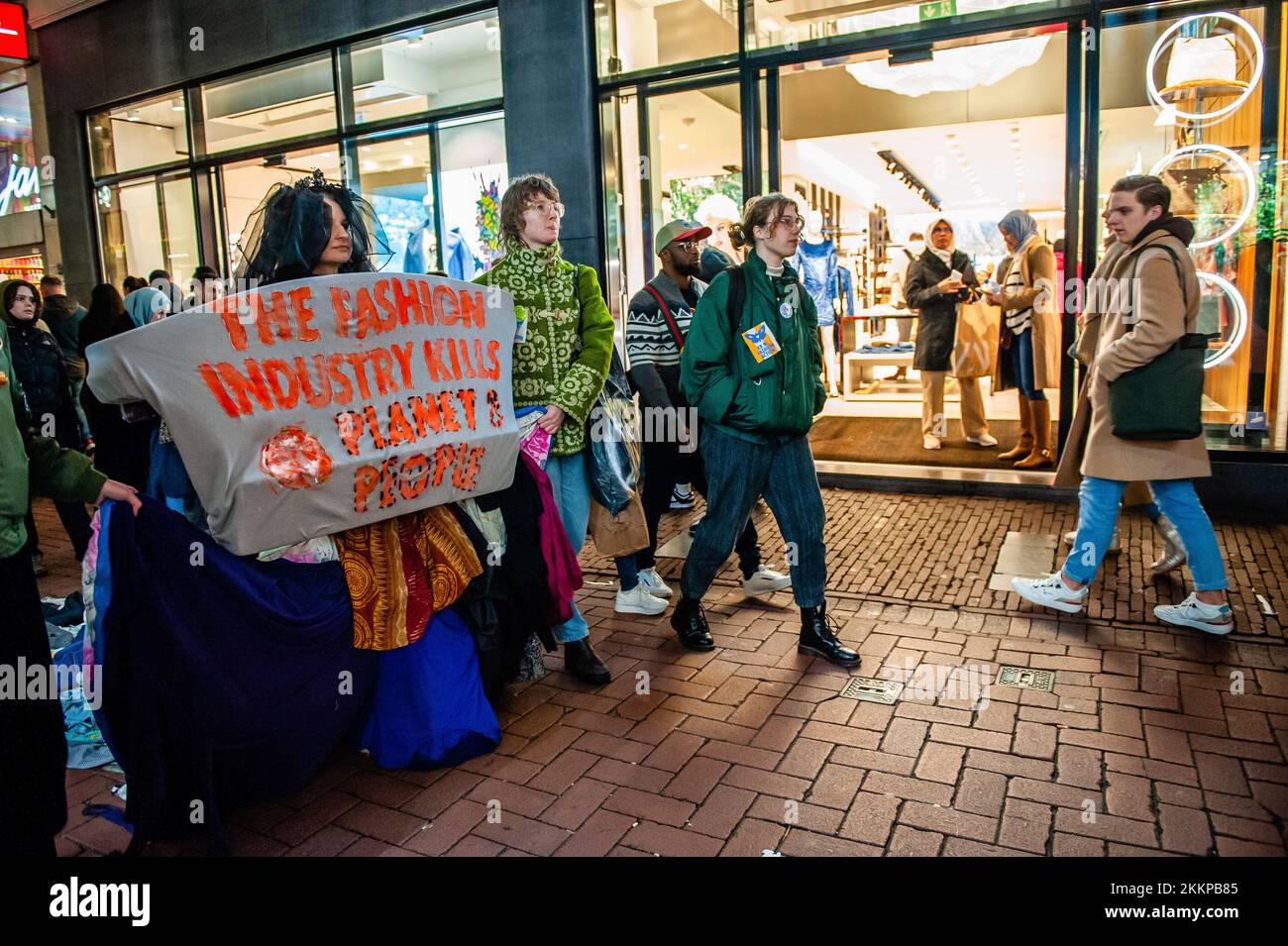 Shoppers watch the XR activists marching on the streets during a ...