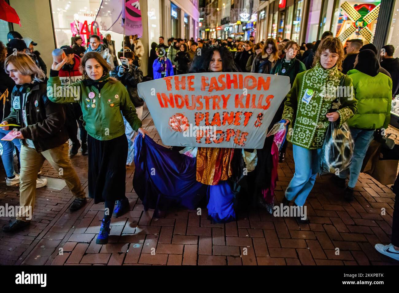 An XR activist marches with a banner against the fashion industry ...