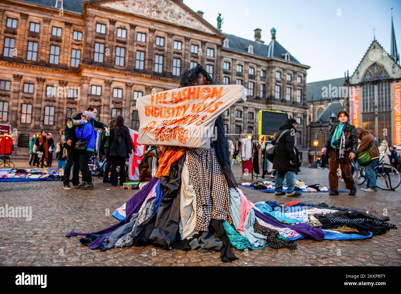 An XR activist wearing a flowing dress made of used cloth materials ...