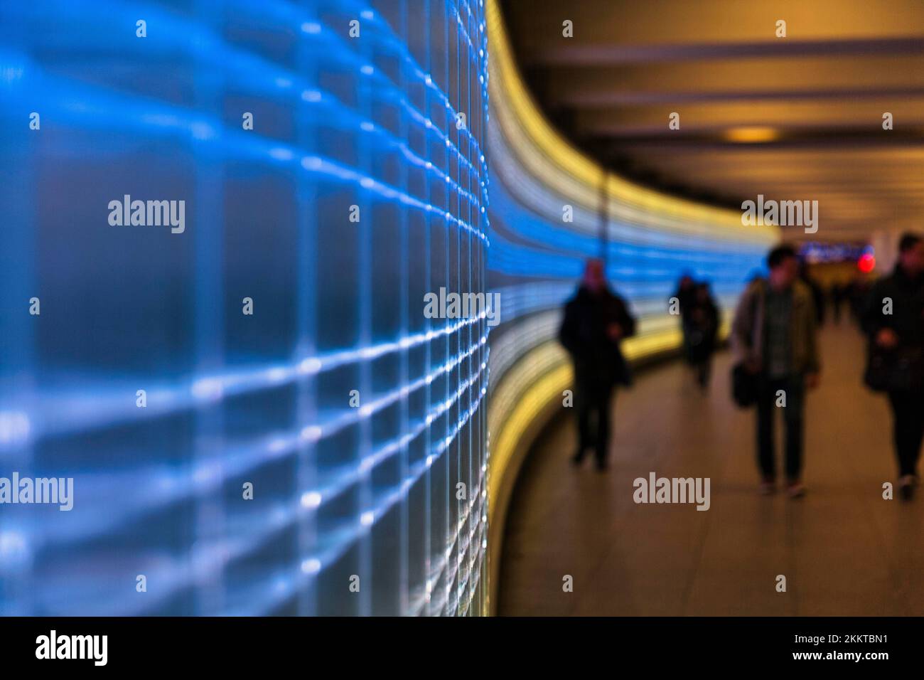 Passers-by in underground passage Passerelle, blue and yellow ...