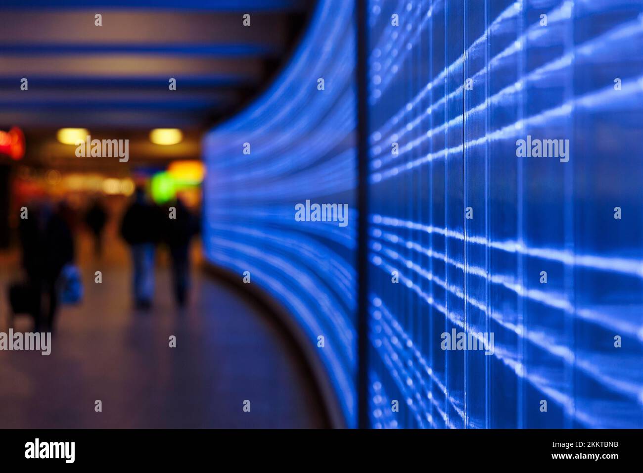 Passers-by in underground passage Passerelle, blue illuminated wall ...