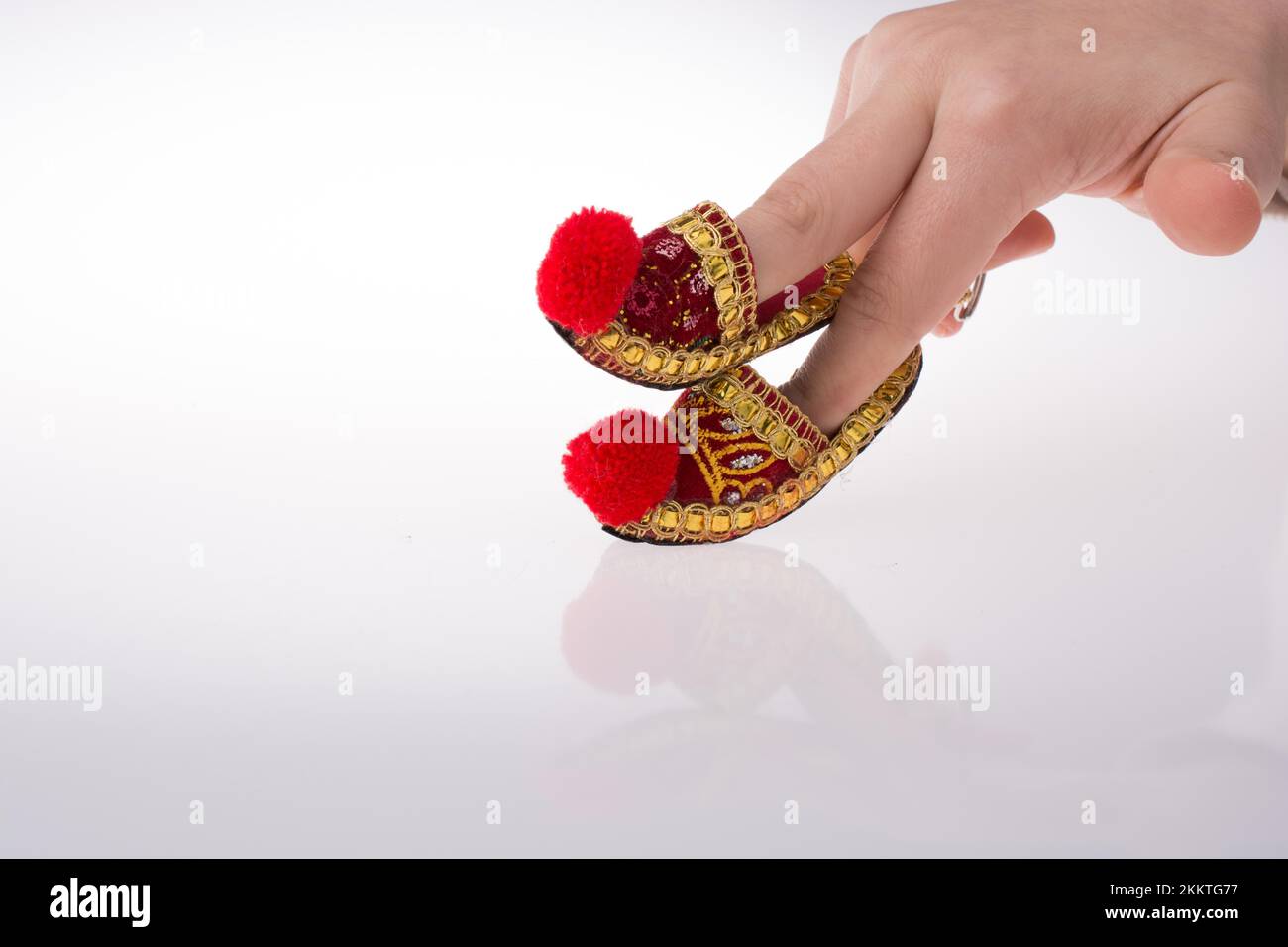 Hand holding traditional Turkish handmade shoes on white background ...