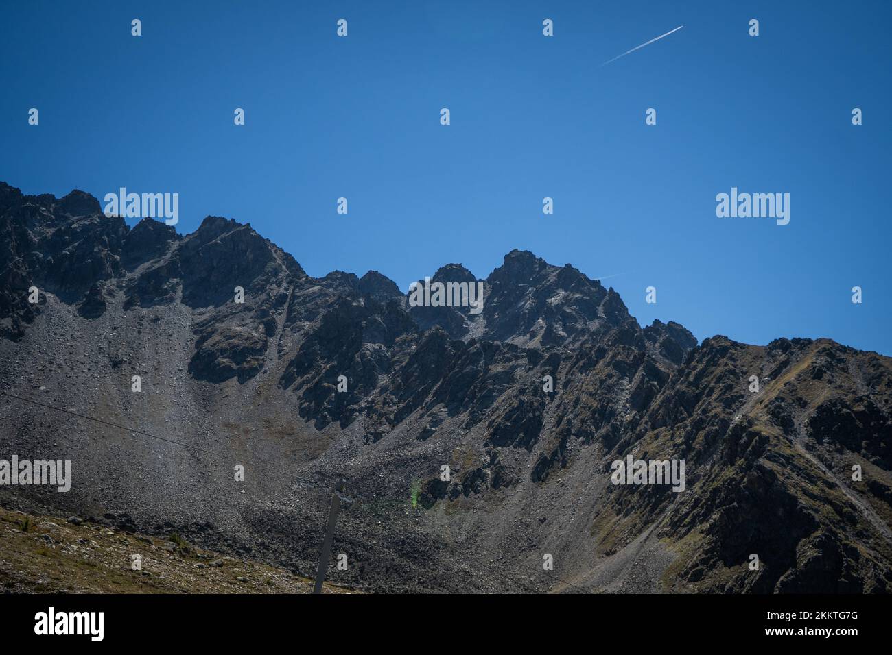 A scenic shot of mountain ridges with sharp peaks under the bright blue ...