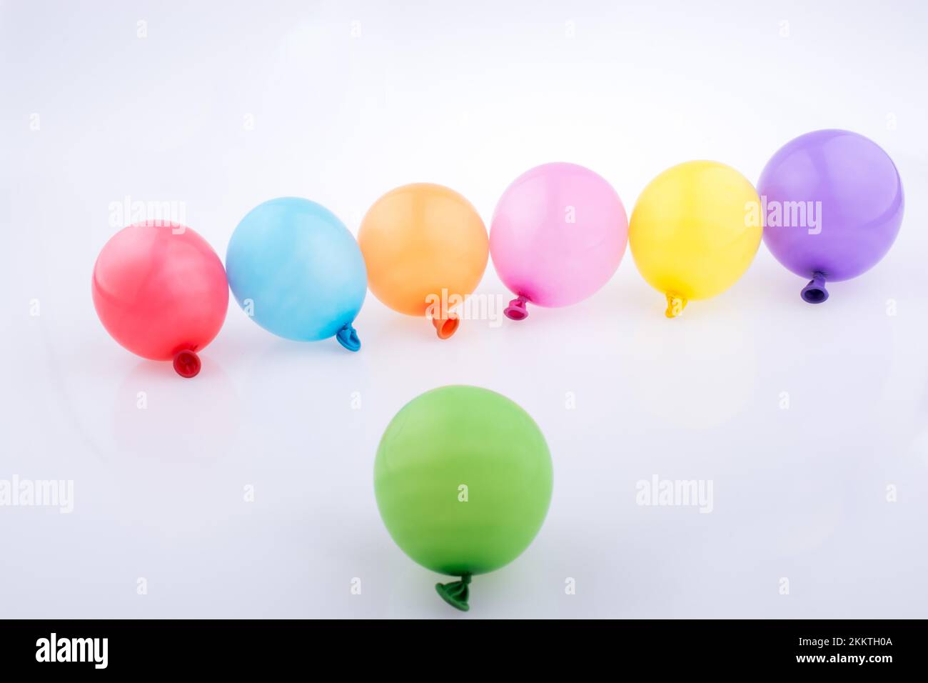 Colorful small balloons in line on a white background Stock Photo - Alamy