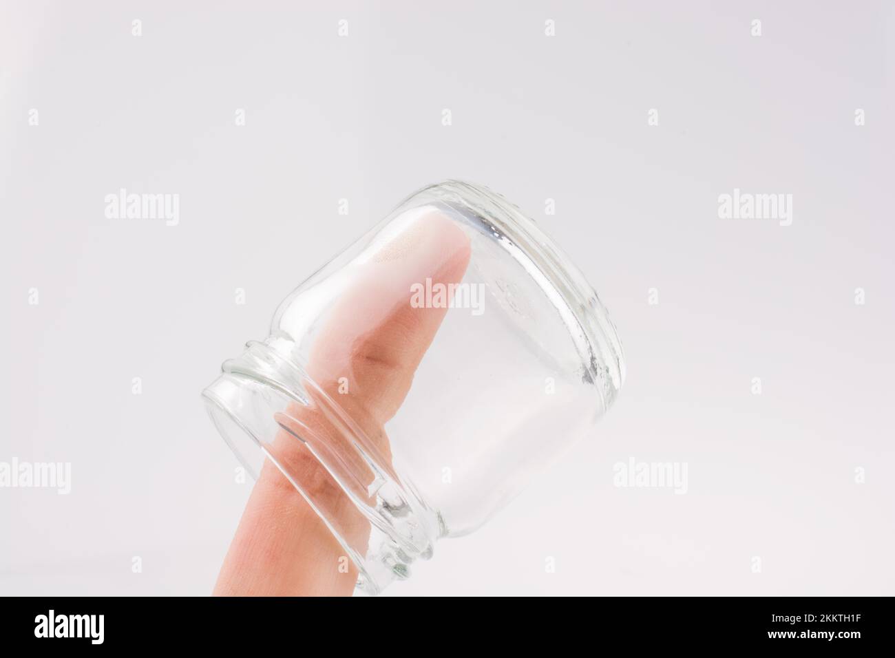 Little empty jar in hand on a white background Stock Photo - Alamy