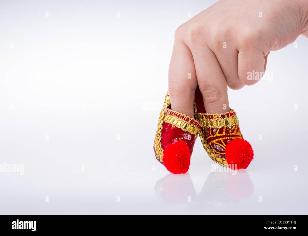 Hand holding traditional Turkish handmade shoes on white background ...