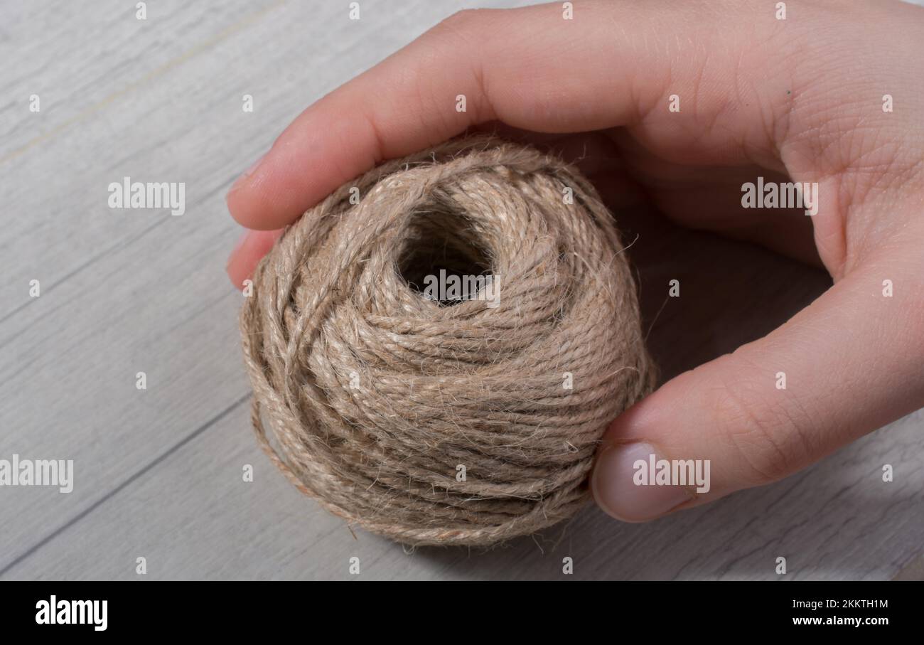Spool of brown string in hand on white background Stock Photo - Alamy