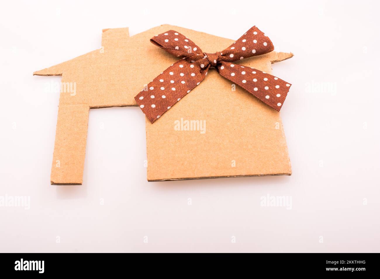 Little house shape cut out of paper with ribbon Stock Photo - Alamy