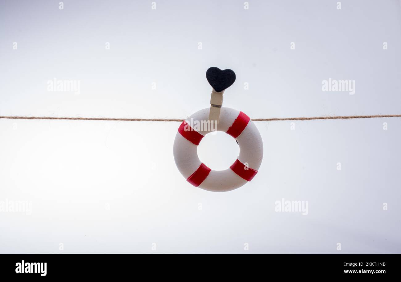 Life preserver attached to a string with heart icon Stock Photo - Alamy