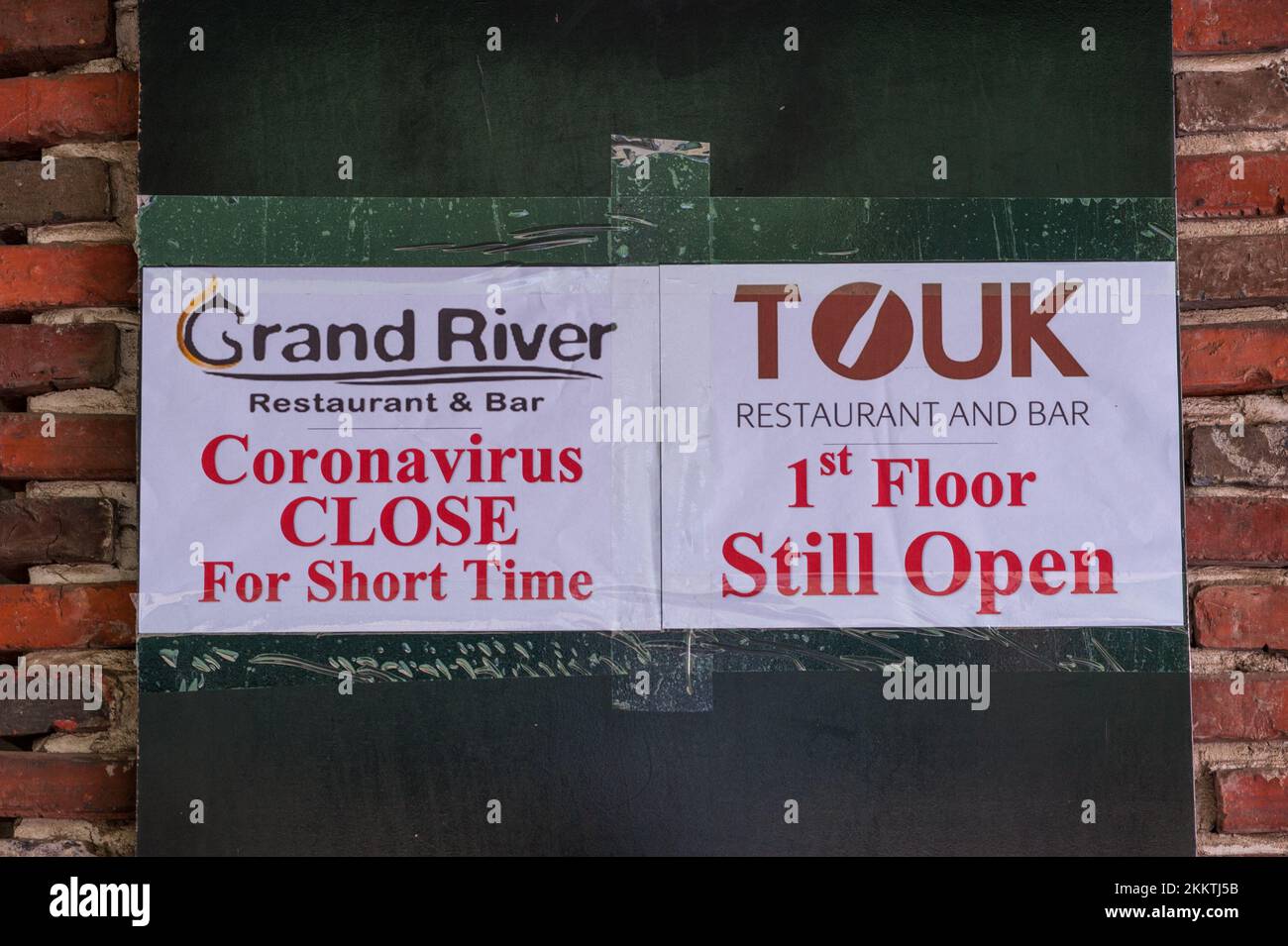 A restaurant on the riverside displays a "Coronavirus CLOSE" sign ...