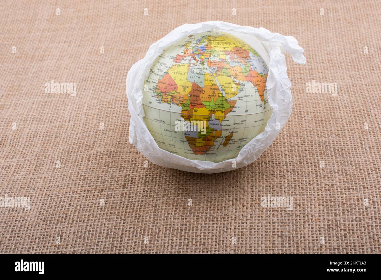 Globe wrapped with paper placed on canvas background Stock Photo - Alamy
