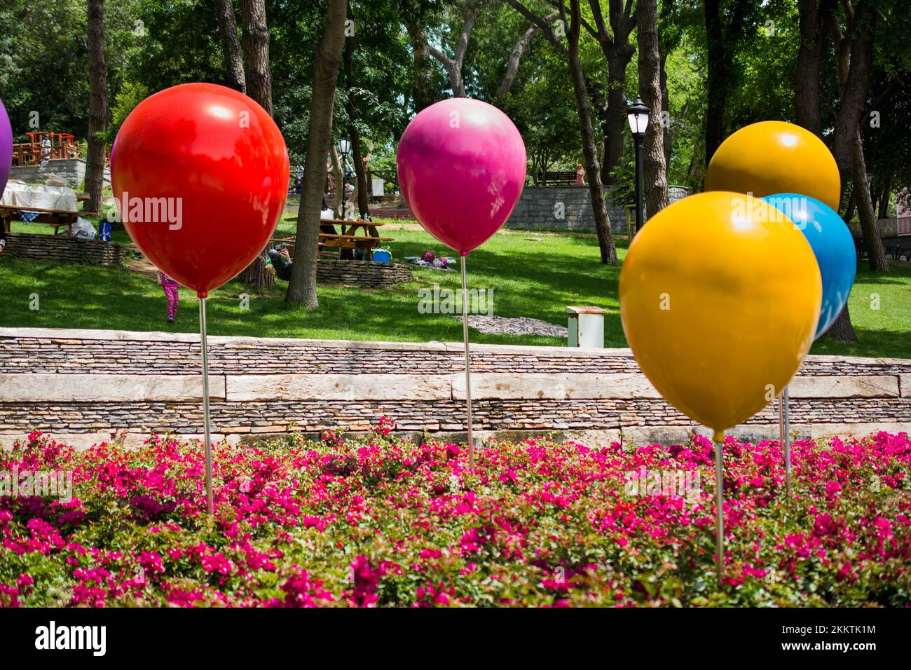 Color baloons are placed in a park by the flowers Stock Photo - Alamy