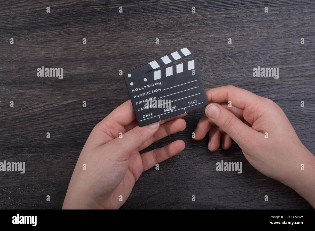 Hand holding movie clapper on a dark background Stock Photo - Alamy