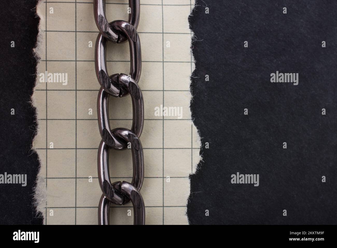 Chain and torn paper on a dark background Stock Photo - Alamy