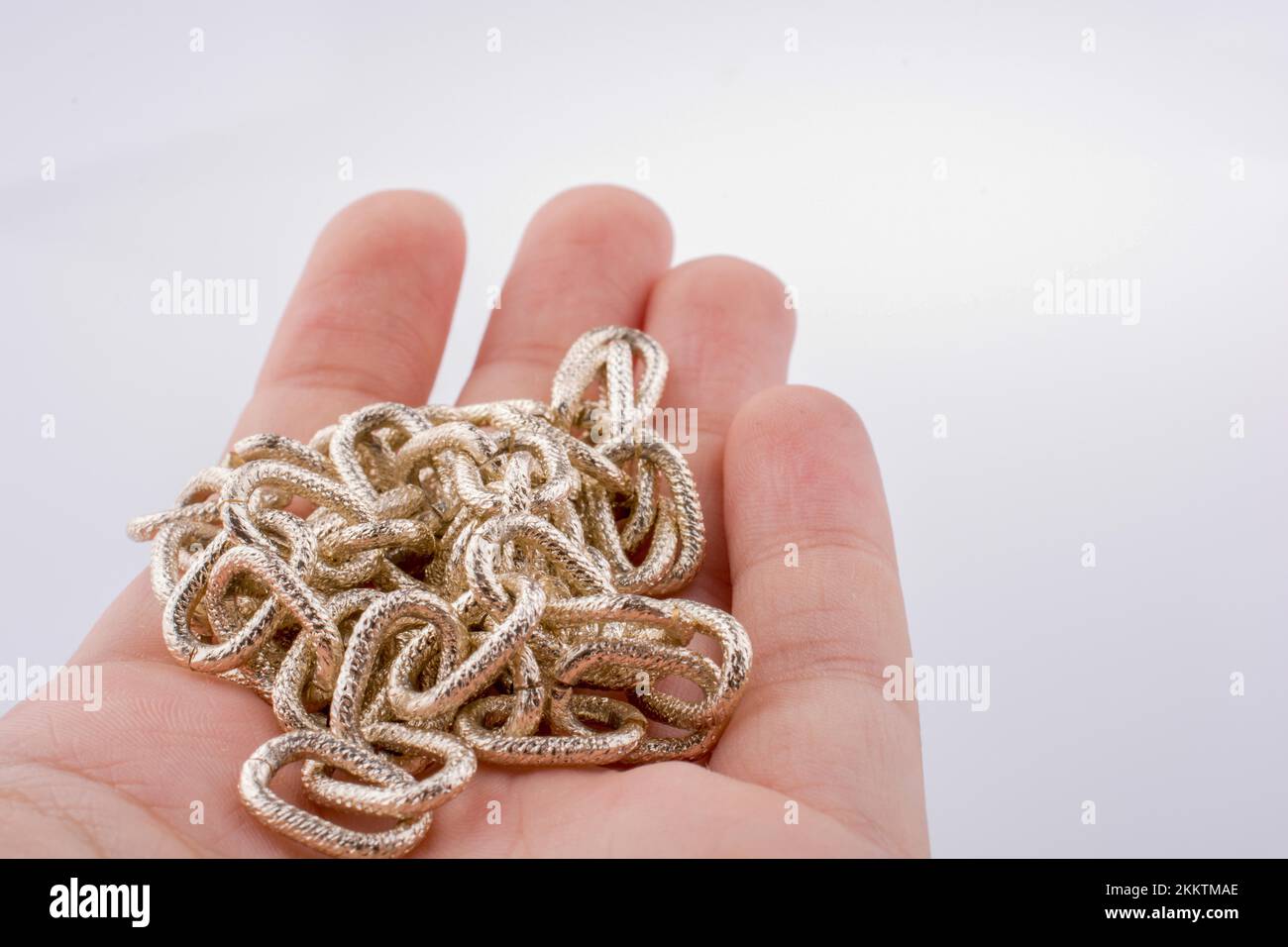 Chain made of gold color in hand Stock Photo - Alamy