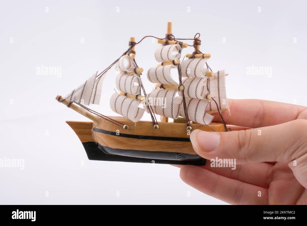 Little colorful model boat in hand on white background Stock Photo - Alamy