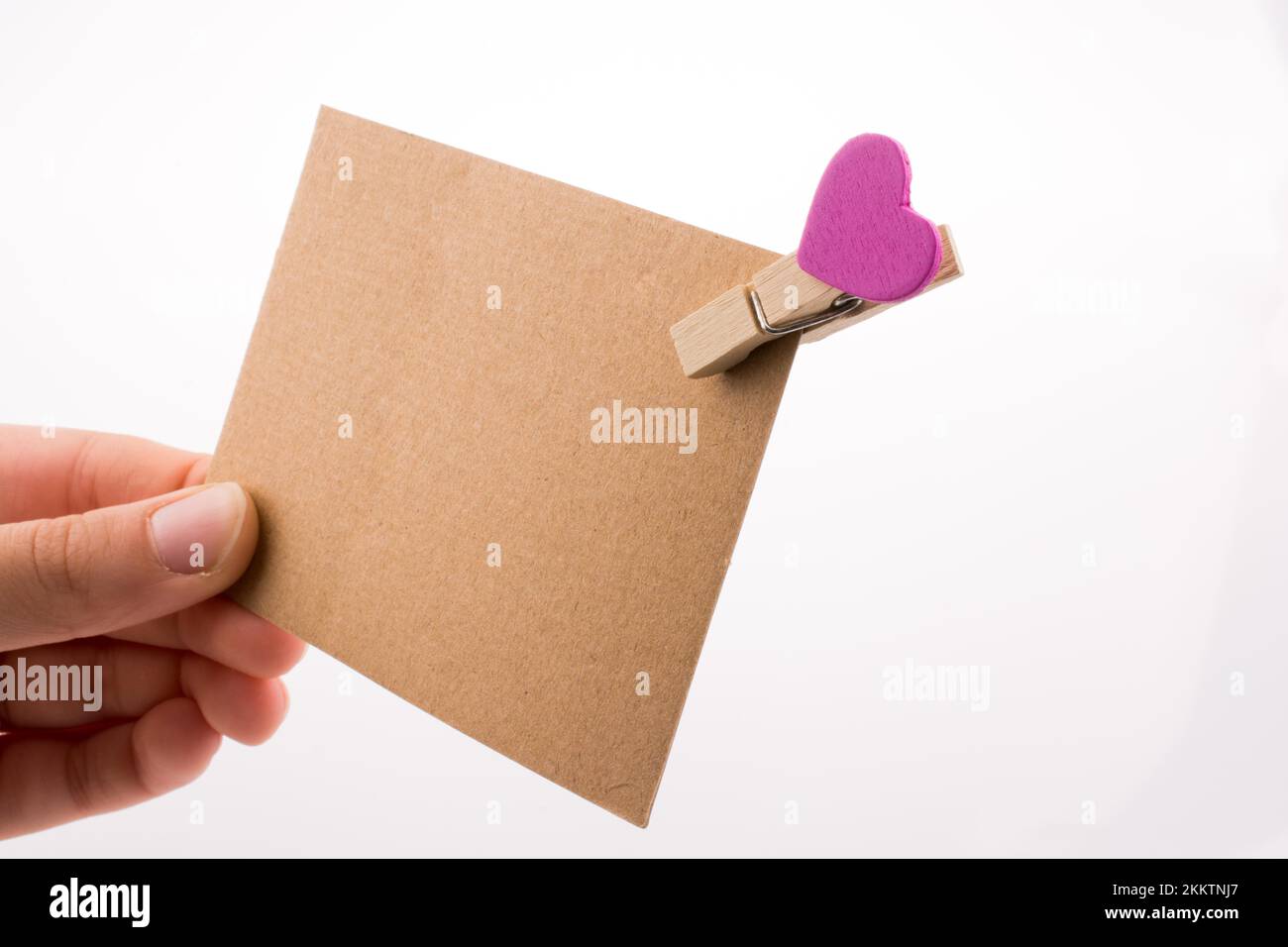 Hand holding a paper with a clip on it Stock Photo - Alamy