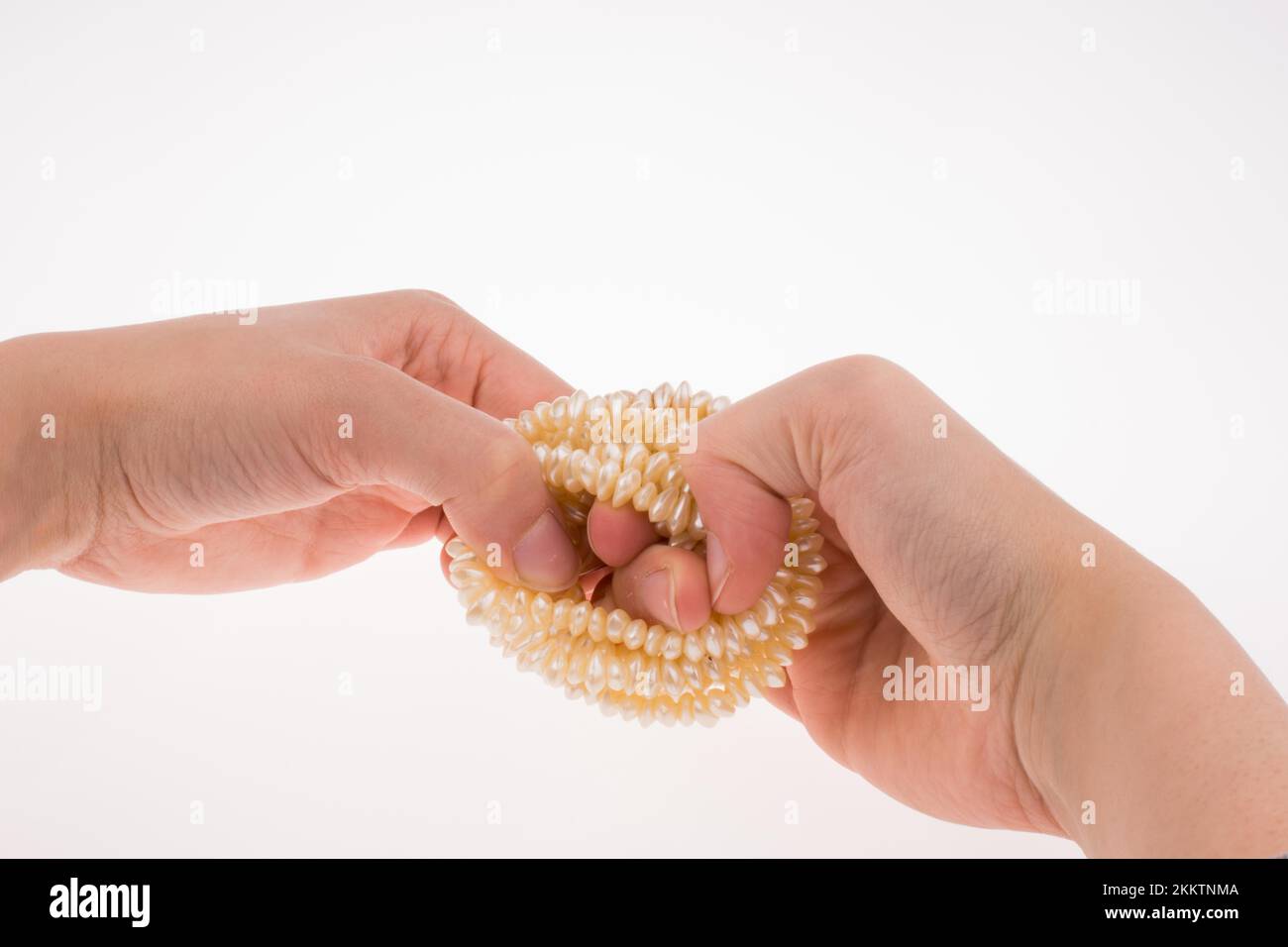 Hand holding pearl necklace on white background Stock Photo - Alamy