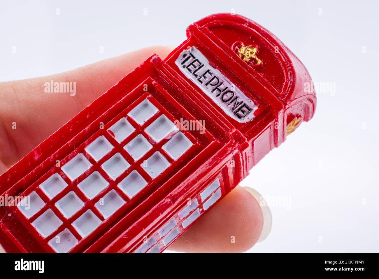 Hand holding a red color phone booth on a white background Stock Photo ...