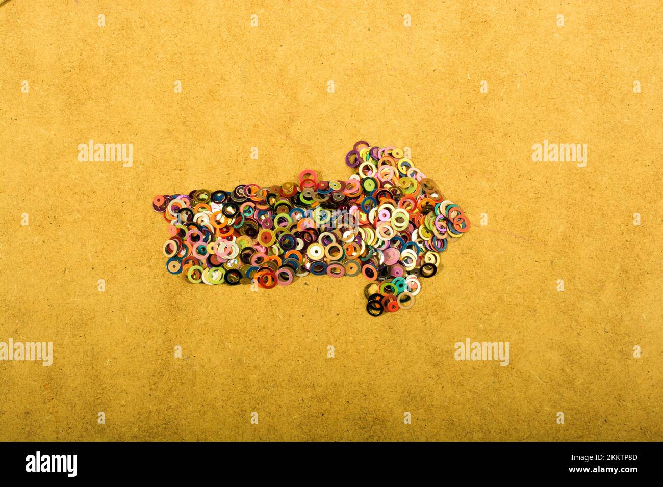 Arrow sign cut out of brown paper in view Stock Photo - Alamy