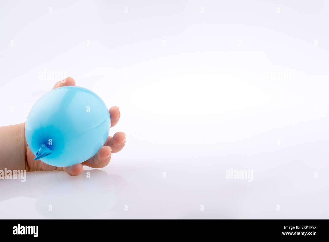 Hand holding a Colorful small balloon on a white background Stock Photo ...