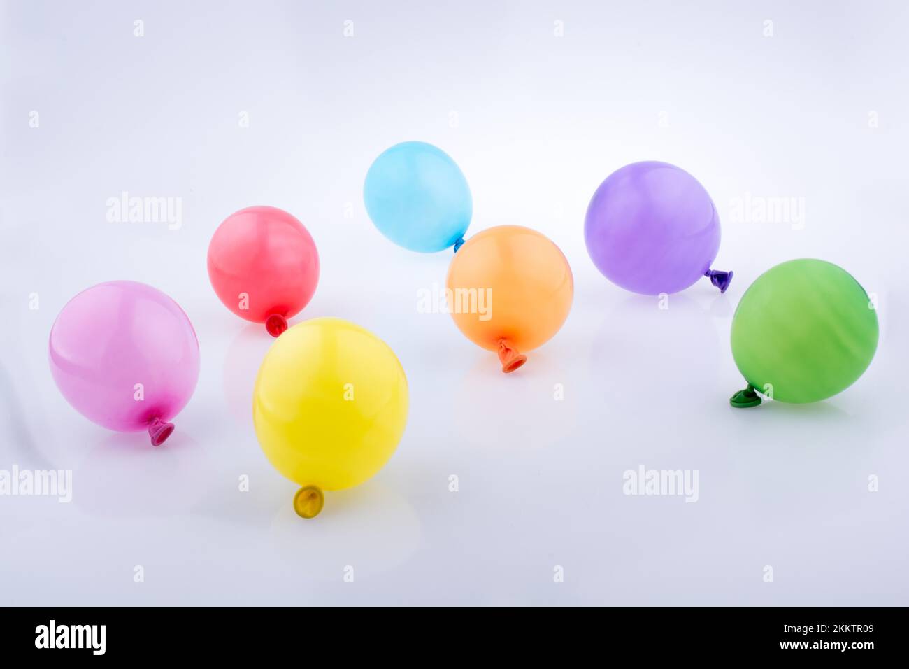 Colorful small balloons on a white background Stock Photo - Alamy