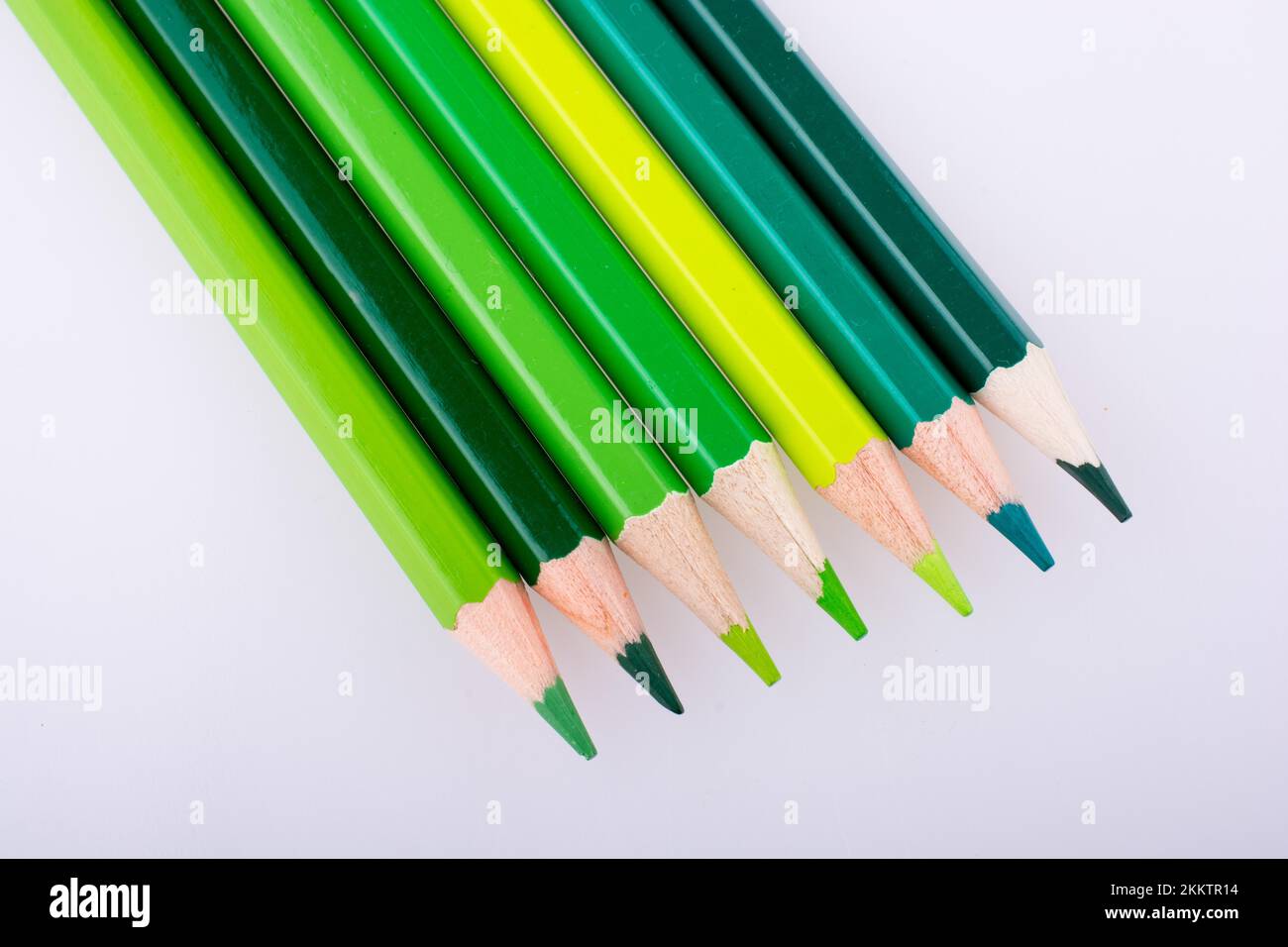 Color Pencils of various tones of green color on a white background ...