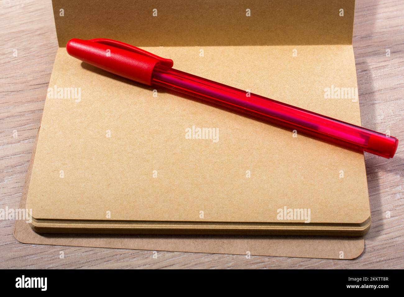 Brown color open notebook and a pen on wooden texture Stock Photo - Alamy