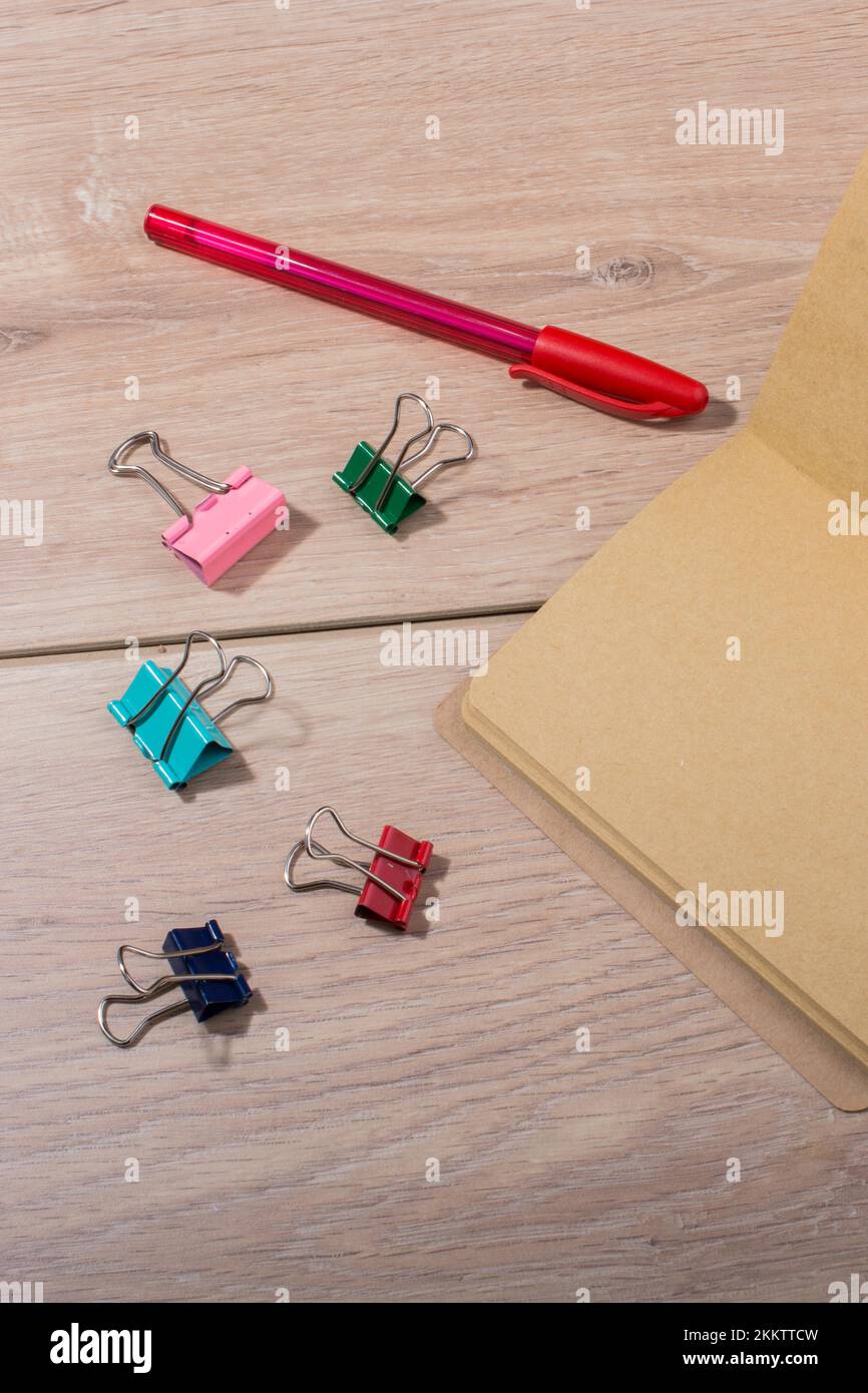Brown color notebook, pen and paper clips on wooden texture Stock Photo ...
