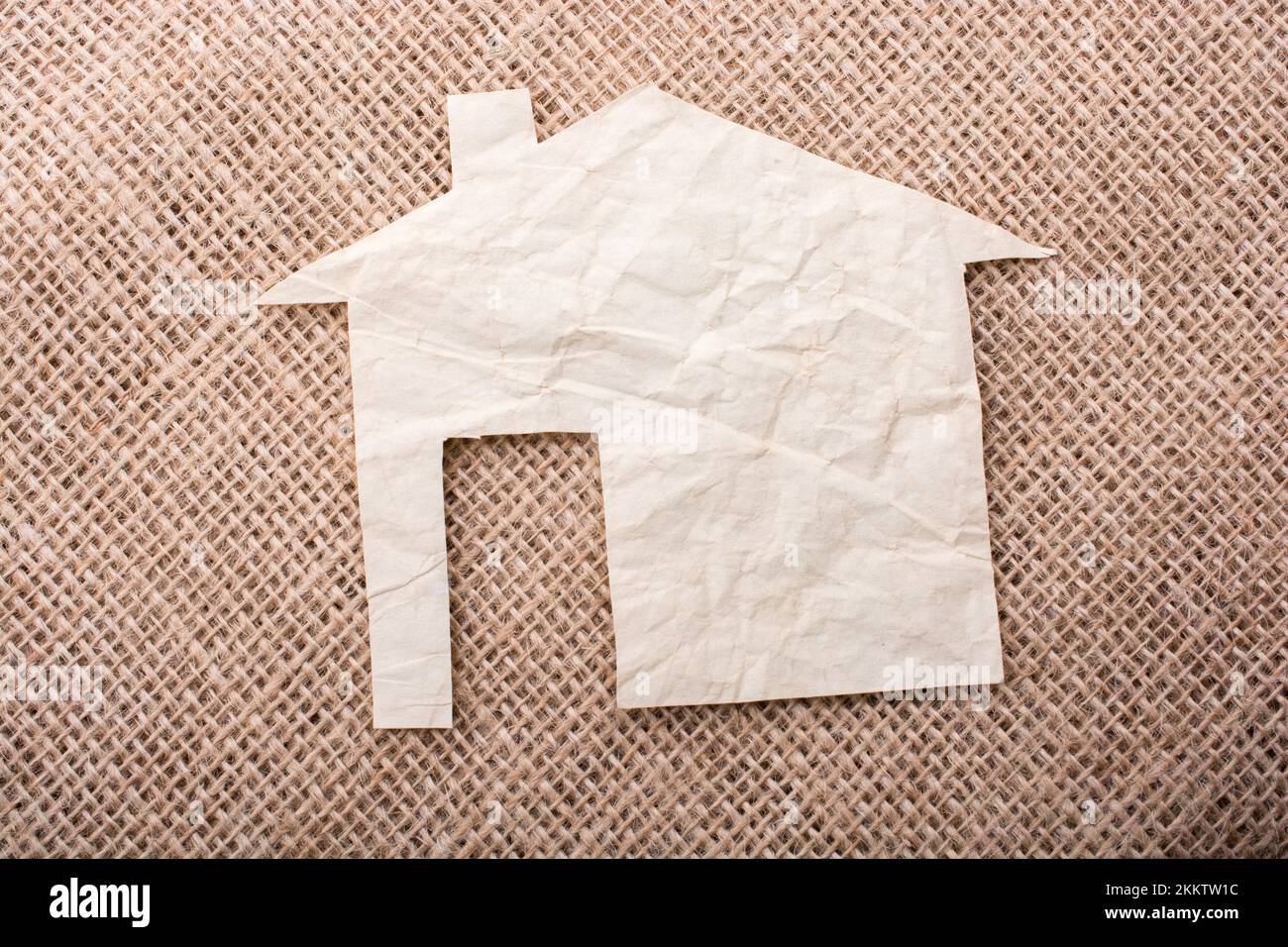 Little house shape cut out of paper on a canvas background Stock Photo ...