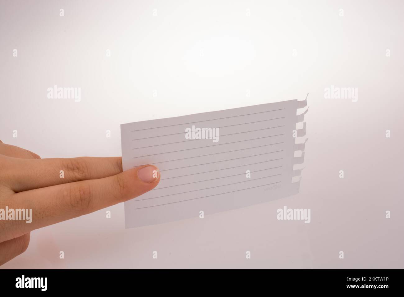 Hand holding a piece of lined paper on a white background Stock Photo ...
