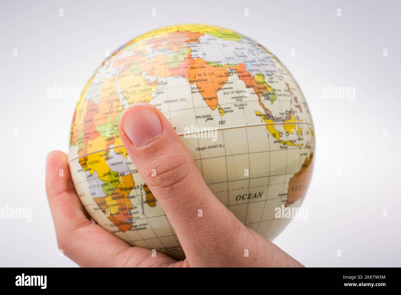 Child holding a globe in on a white background Stock Photo - Alamy