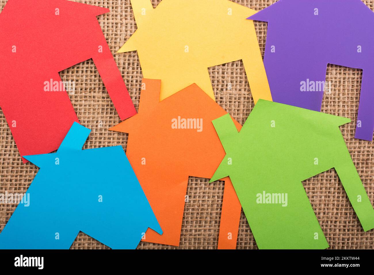 Little house shape cut out of colorful paper on a canvas background ...