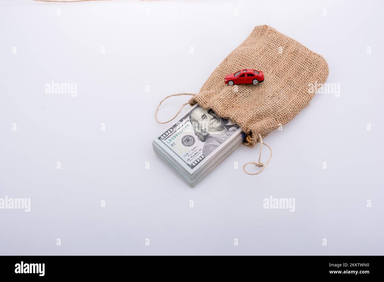 Toy car and bundle of US dollar in a sack on a white background Stock ...