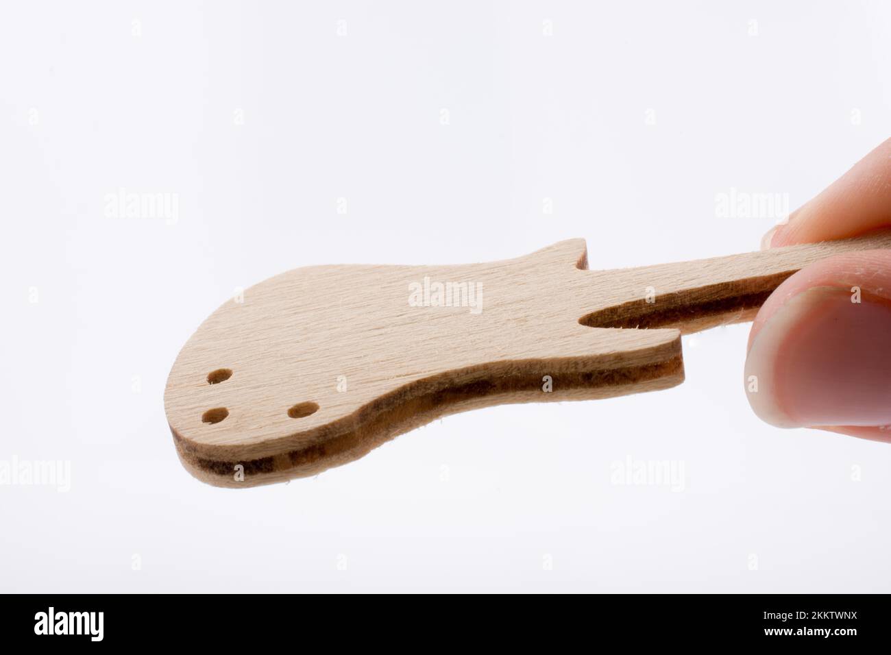 Mini wooden guitar model in hand on a white background Stock Photo - Alamy