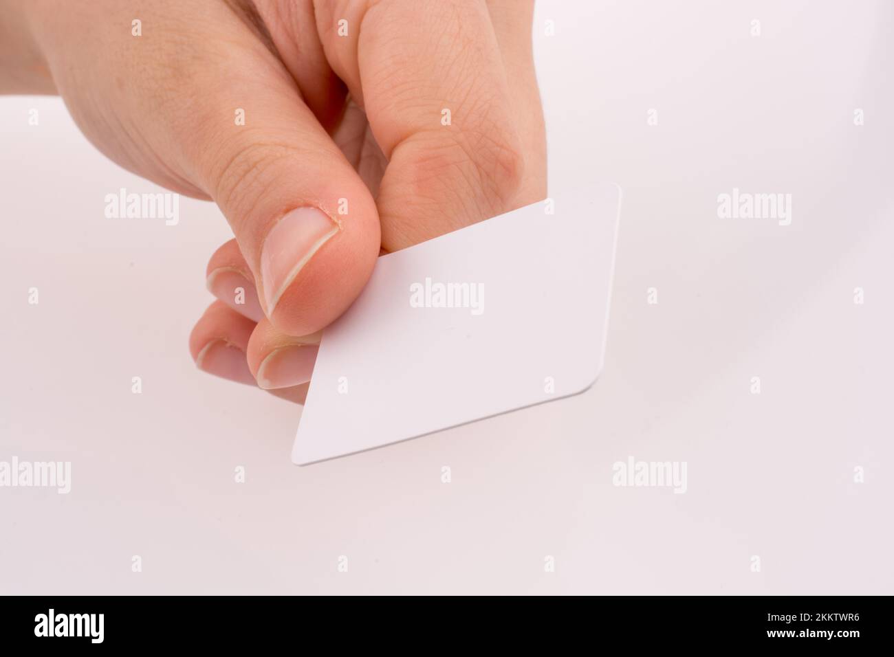 Hand holding a piece of paper on a white background Stock Photo - Alamy