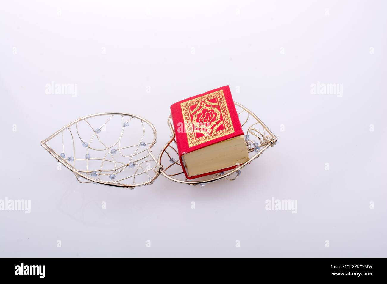 The Holy Quran in mini size in a heart shaped cage Stock Photo - Alamy