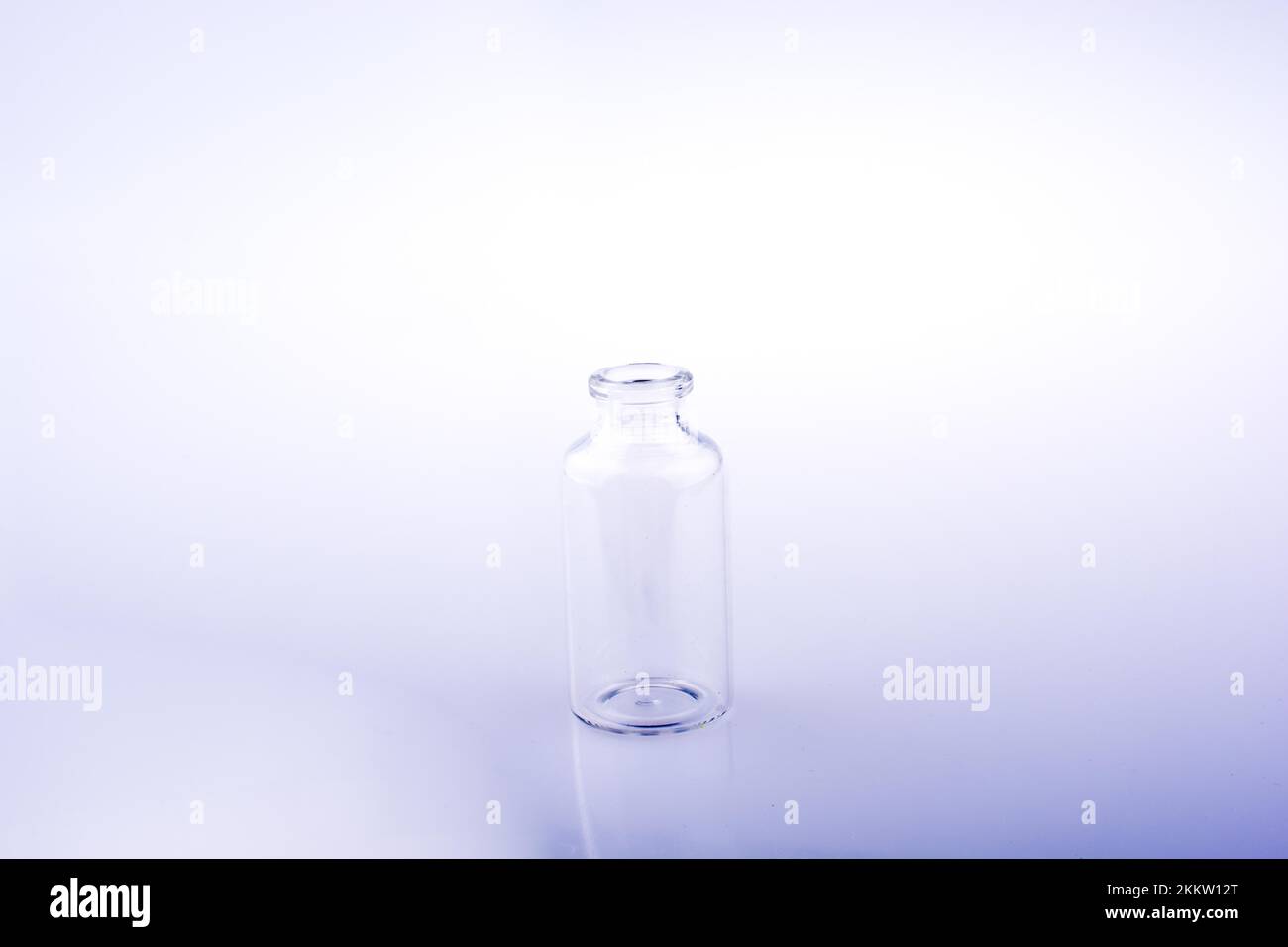 Little glass bottle in hand on a white background Stock Photo - Alamy