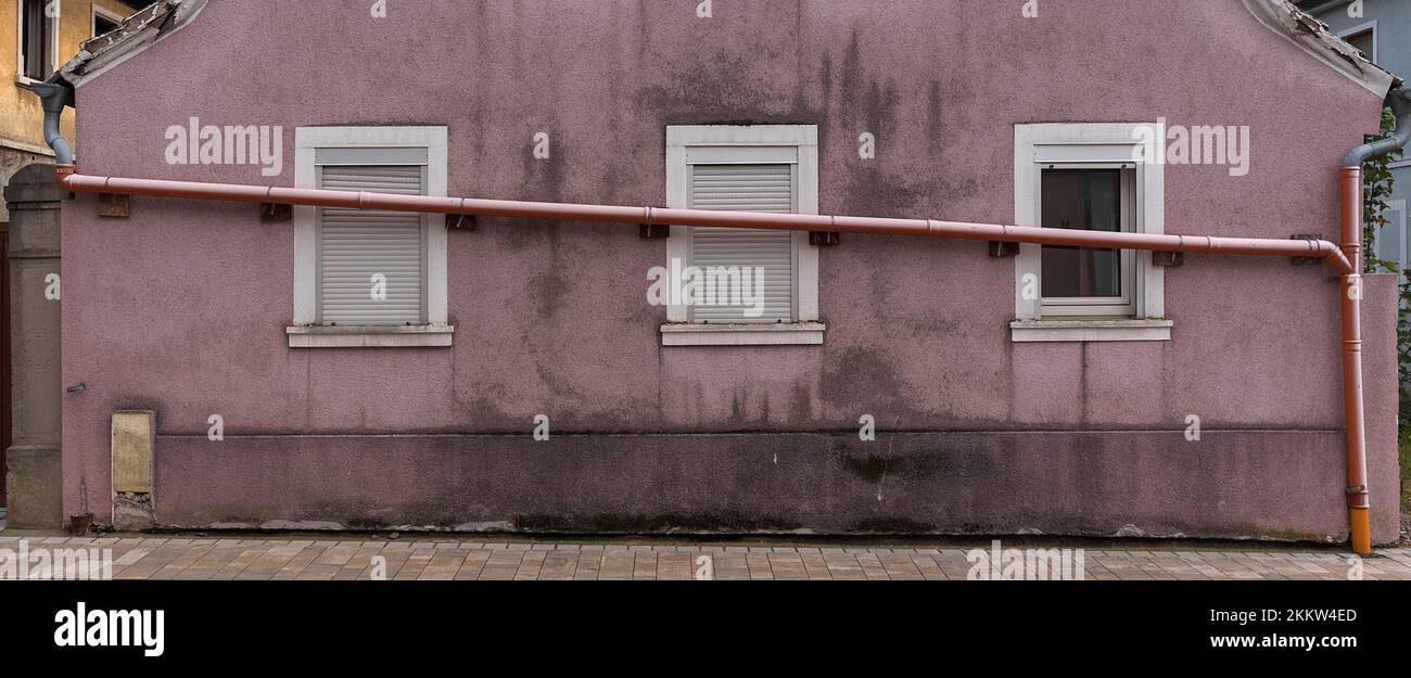 Drain pipe runs across the windows of a single-family house, Theres ...