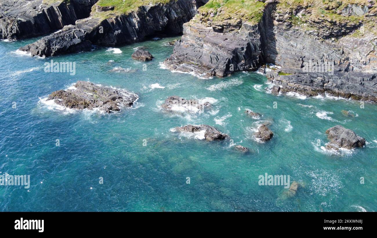 Steep cliffs on the southern coast of Ireland. Turquoise waters of the Atlantic Ocean. Natural ...