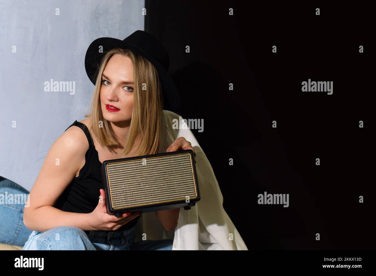 Cool young woman wears hat and casual outfit posing with radio receiver ...