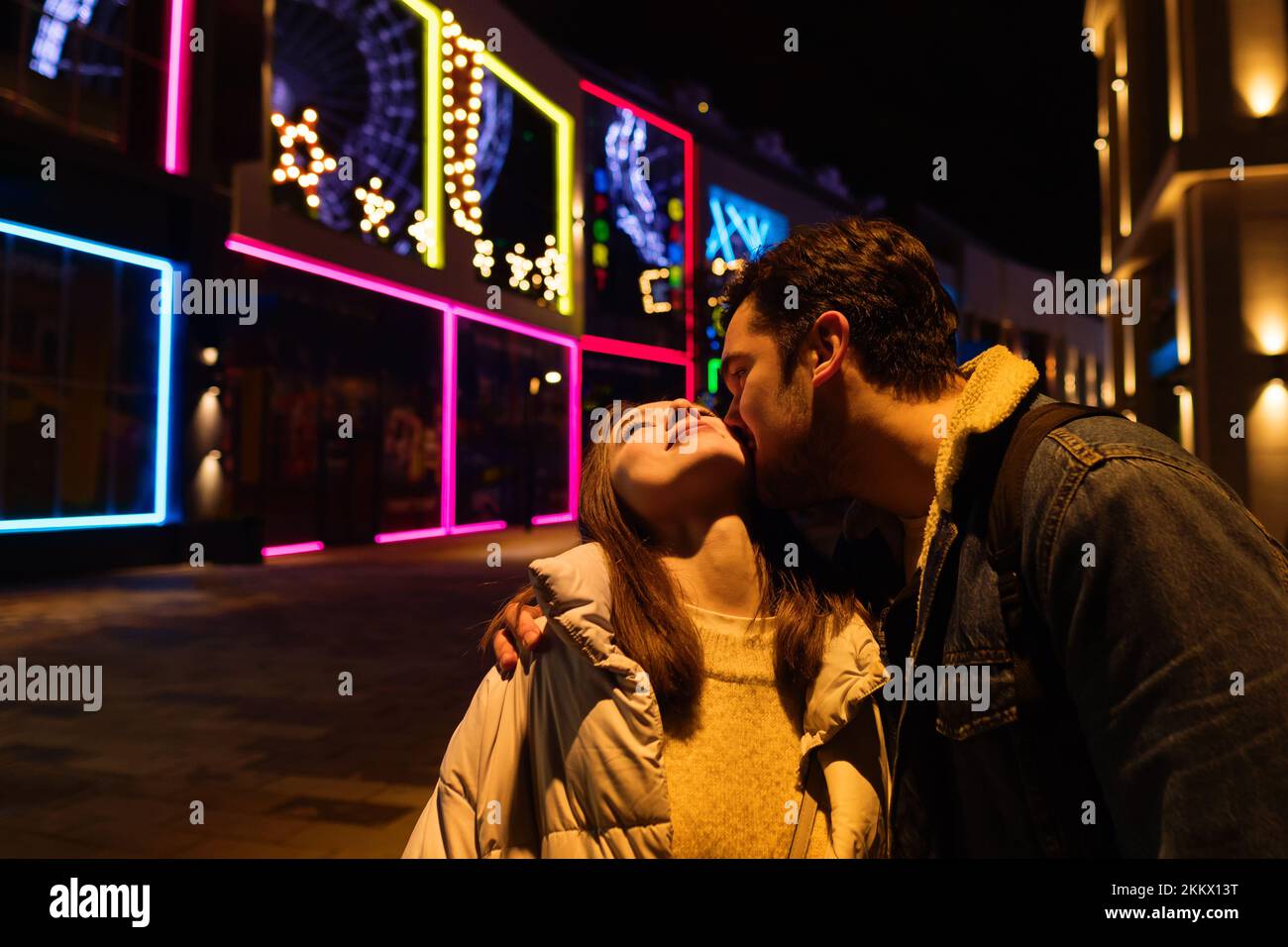 Young romantic couple having fun outdoors in night city street. Enjoy ...