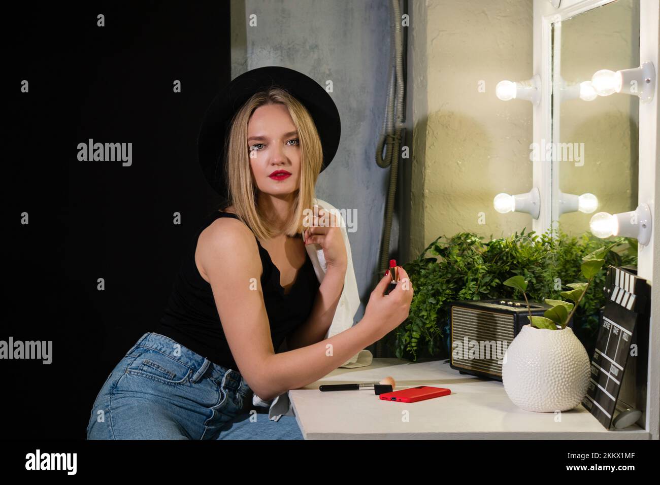Stylish young beauty woman at dressing room mirror. Lovely girl wears ...