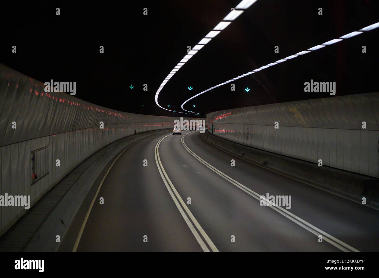 A modern curving tunnel with cars and illuminated lights Stock Photo ...